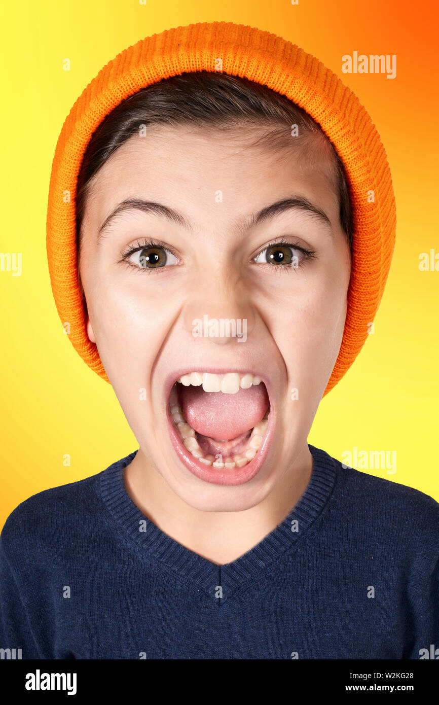 portrait of screaming young boy with big head on orange background ...