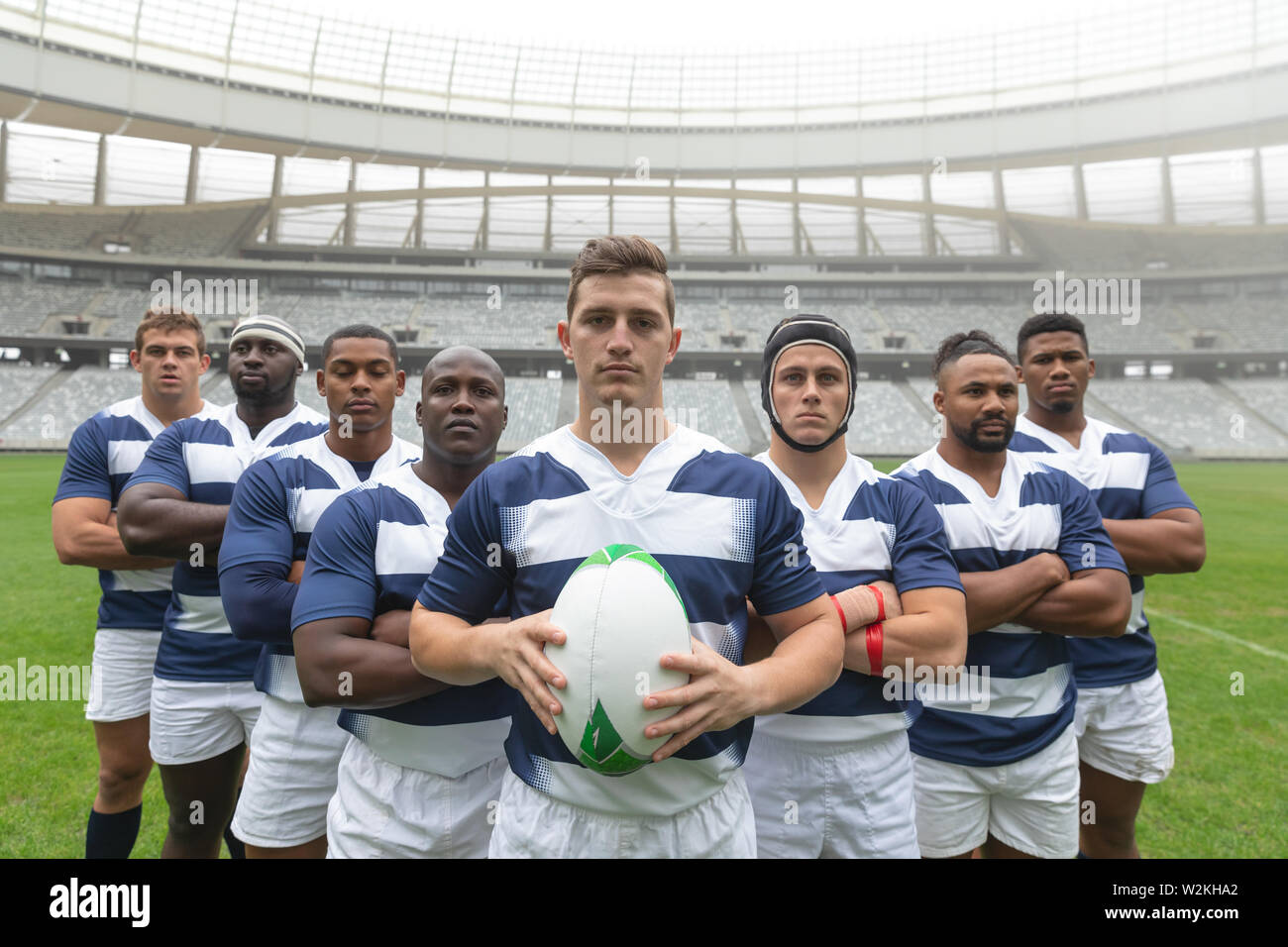 Group of diverse male rugby players standing together with rugby ball ...
