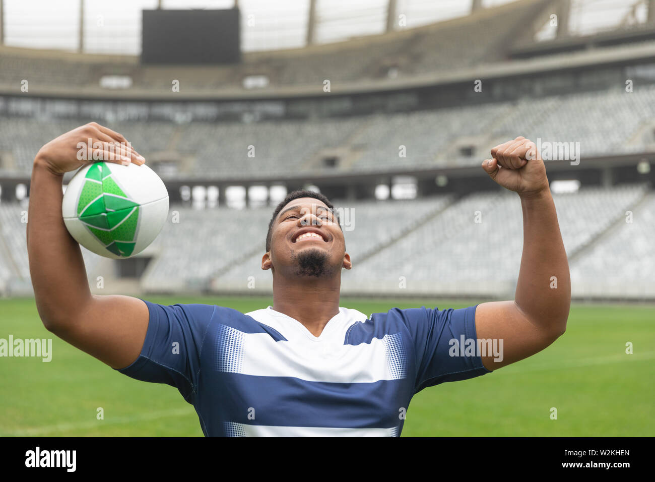 Happy African American Rugby player cheering with the ball in the ...