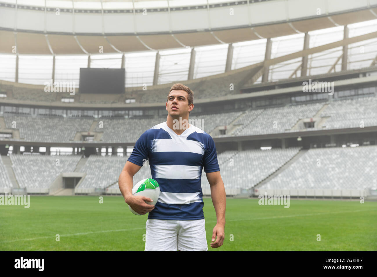 Caucasian rugby player standing with rugby ball in stadium Stock Photo ...