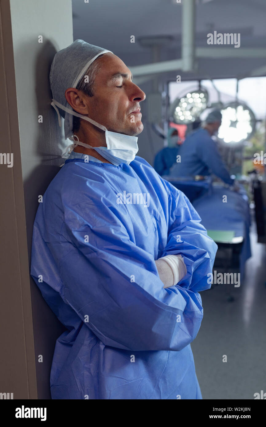 Upset male surgeon standing in operation room at hospital Stock Photo ...