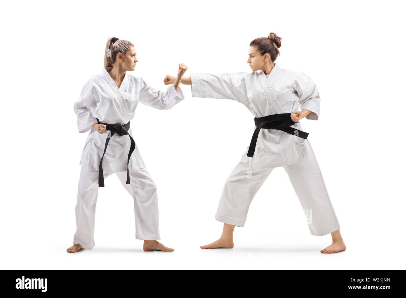 Full length profile shot of two females in kimonos practicing karate ...