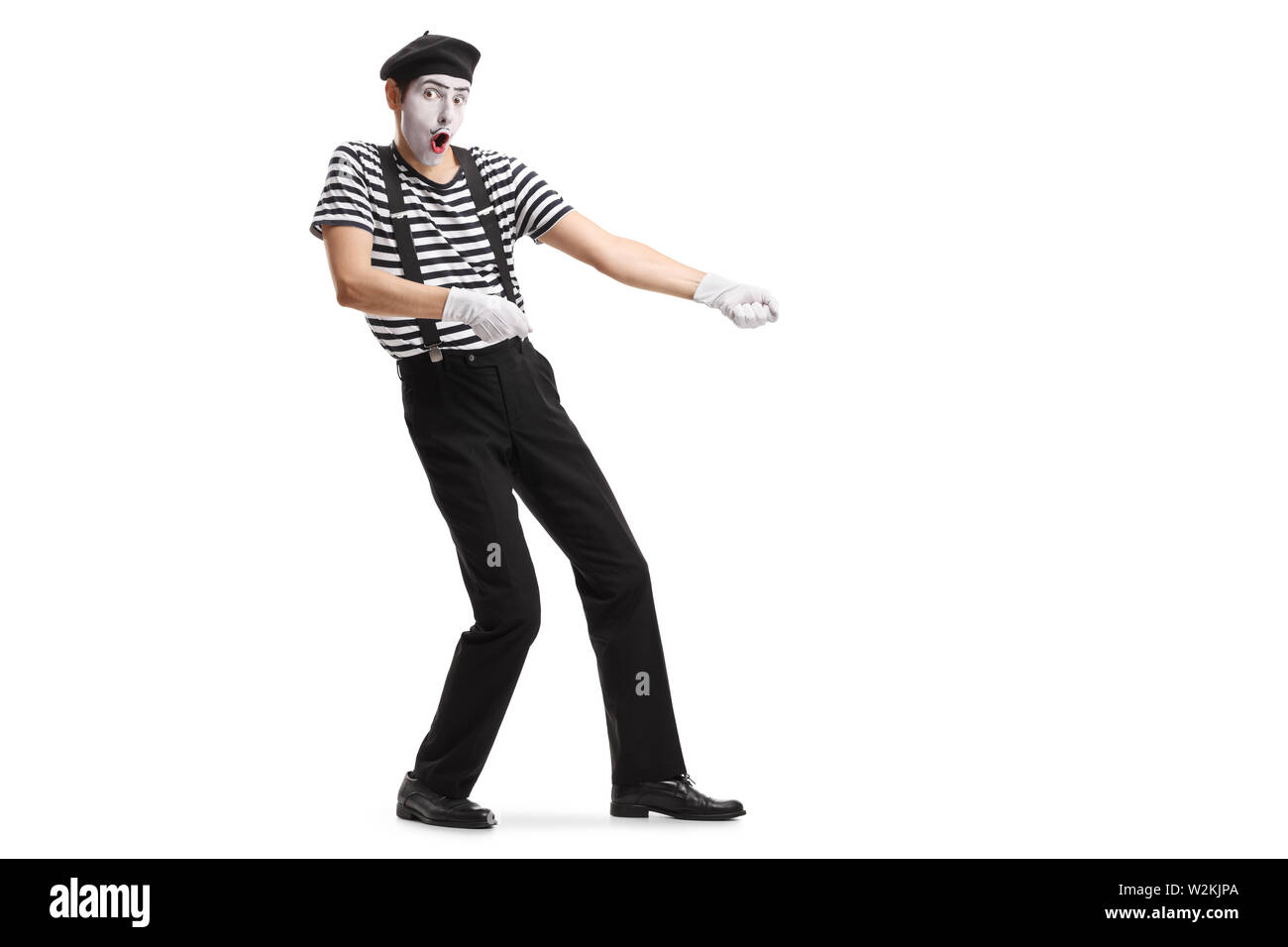 Full length shot of a mime pretending to pull a rope isolated on white ...