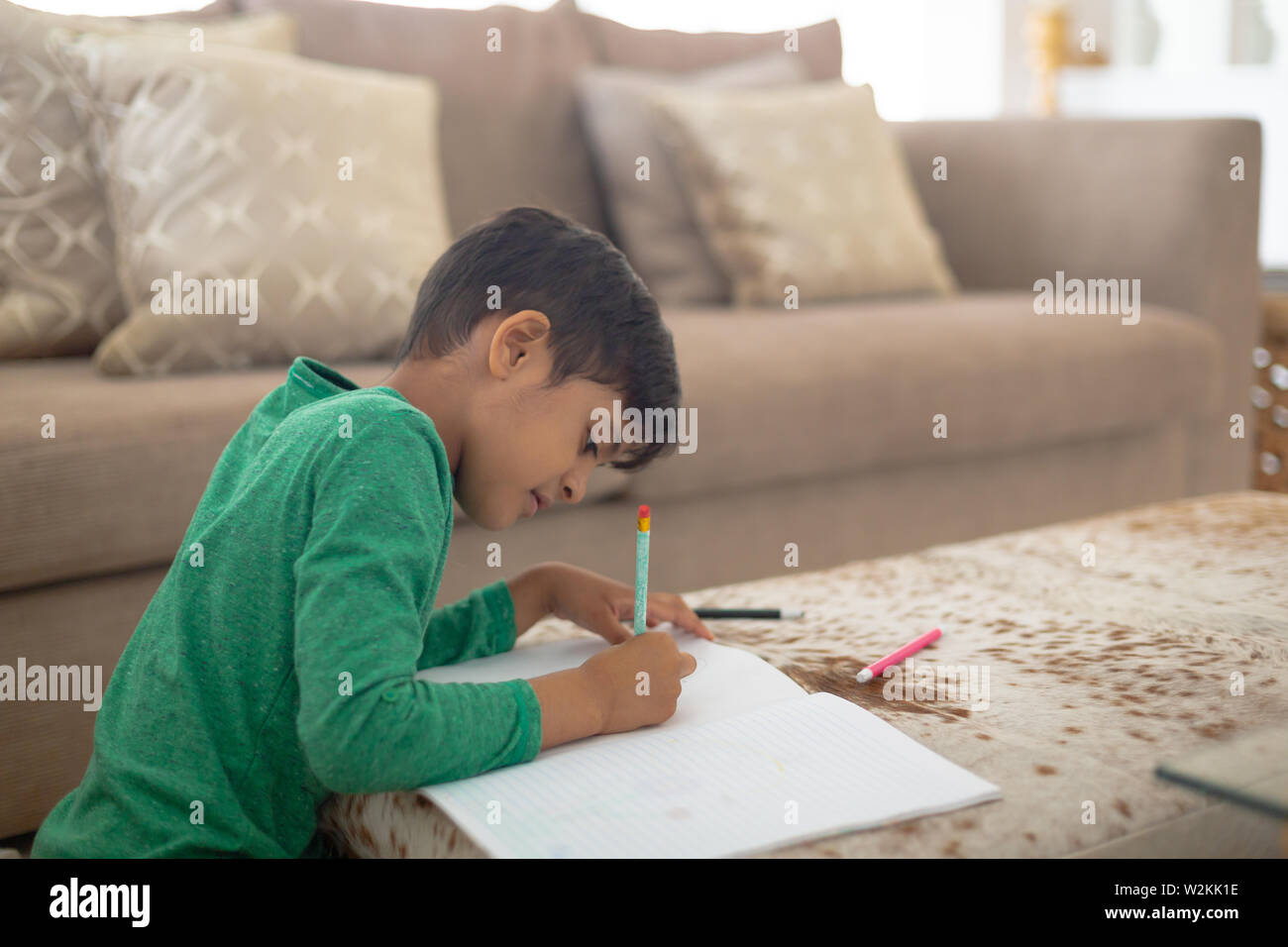 Boy drawing a sketch on book at home Stock Photo - Alamy
