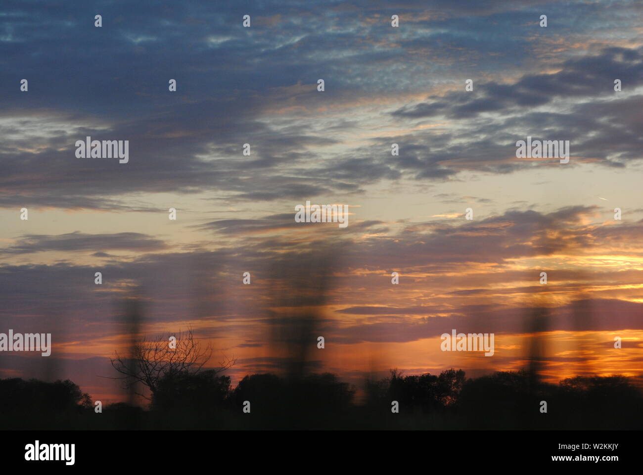 A colourful sunset with golden sky and dark blue, indigo clouds Stock ...
