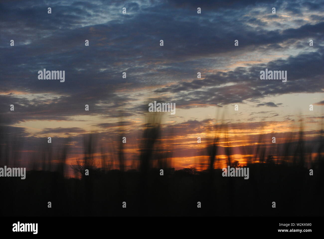 A colourful sunset with golden sky and dark blue, indigo clouds Stock ...