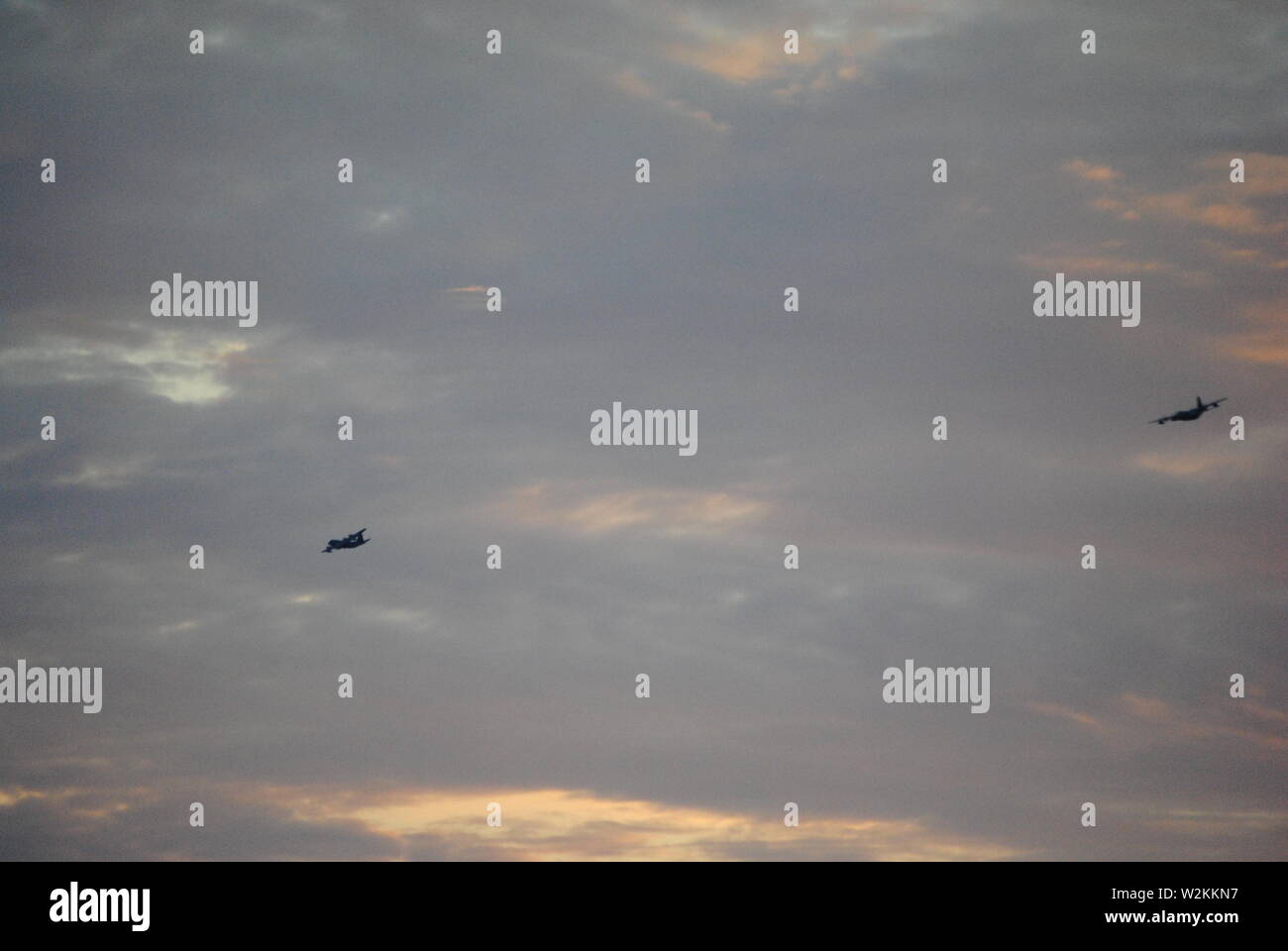 pair of C 130 Hercules aircraft in the sky of a sunsetting sky with ...
