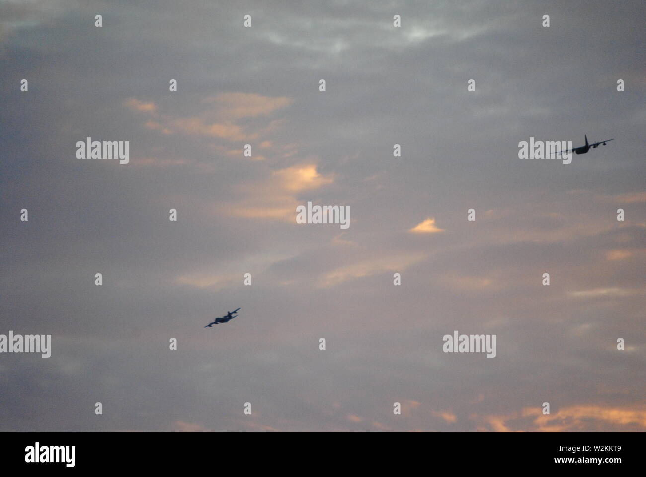 pair of C 130 Hercules aircraft in the sky of a sunsetting sky with ...