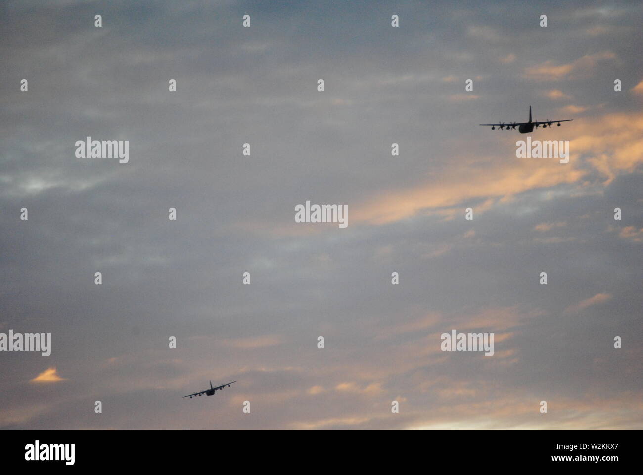 pair of C 130 Hercules aircraft in the sky of a sunsetting sky with ...