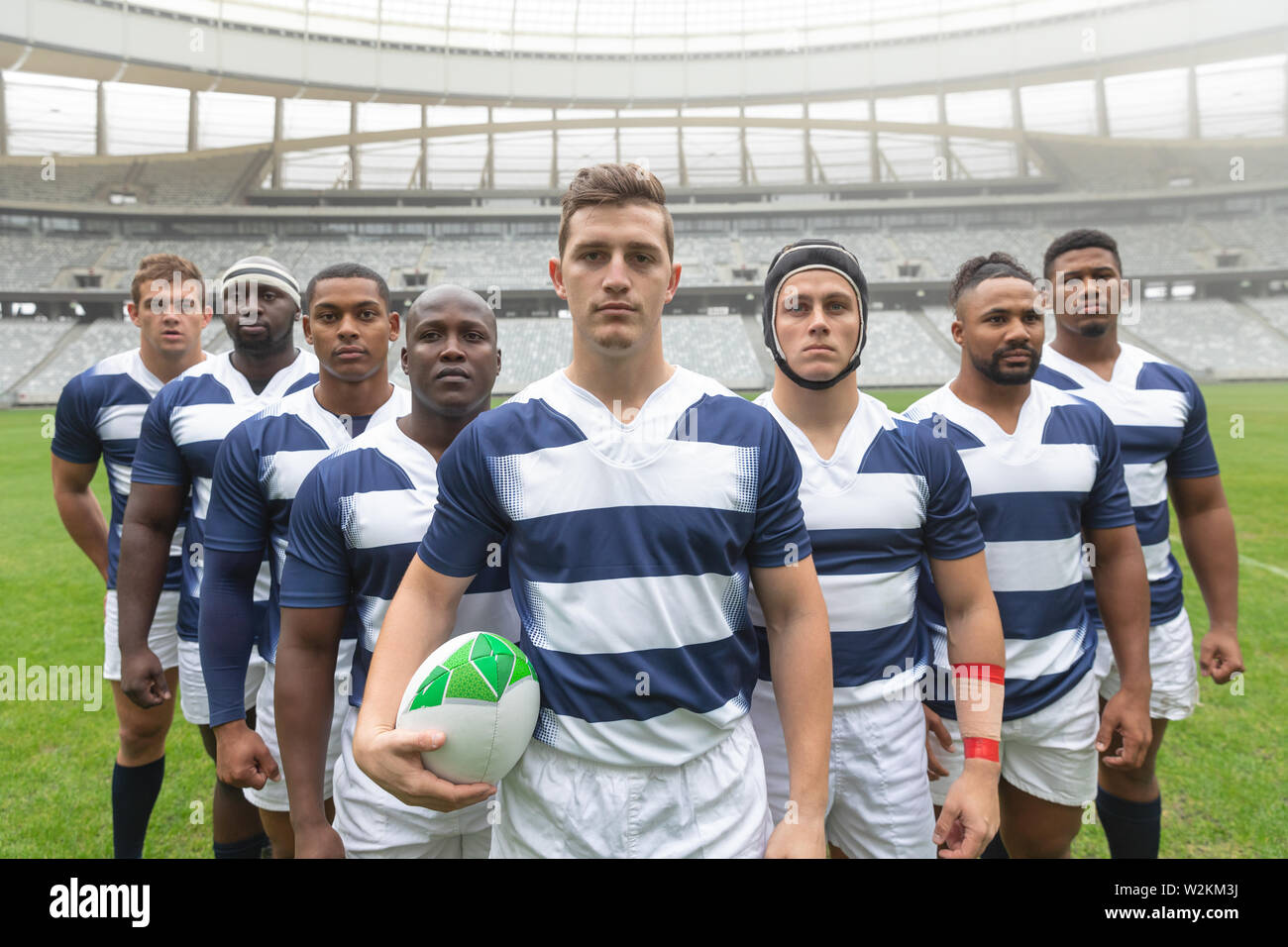 Group of diverse male rugby players standing together with rugby ball ...