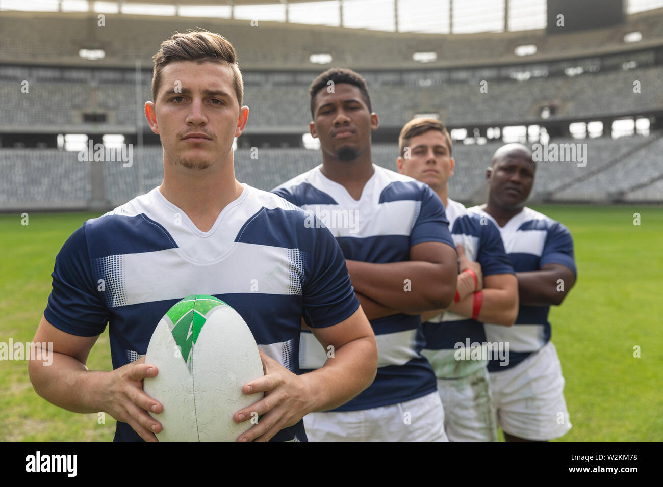 Male rugby players standing together with rugby ball in stadium Stock ...
