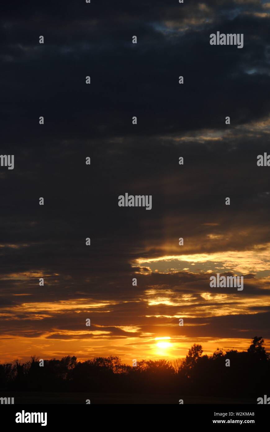 sunset over the fields of suffolk, summer orange yellow sun with dark ...