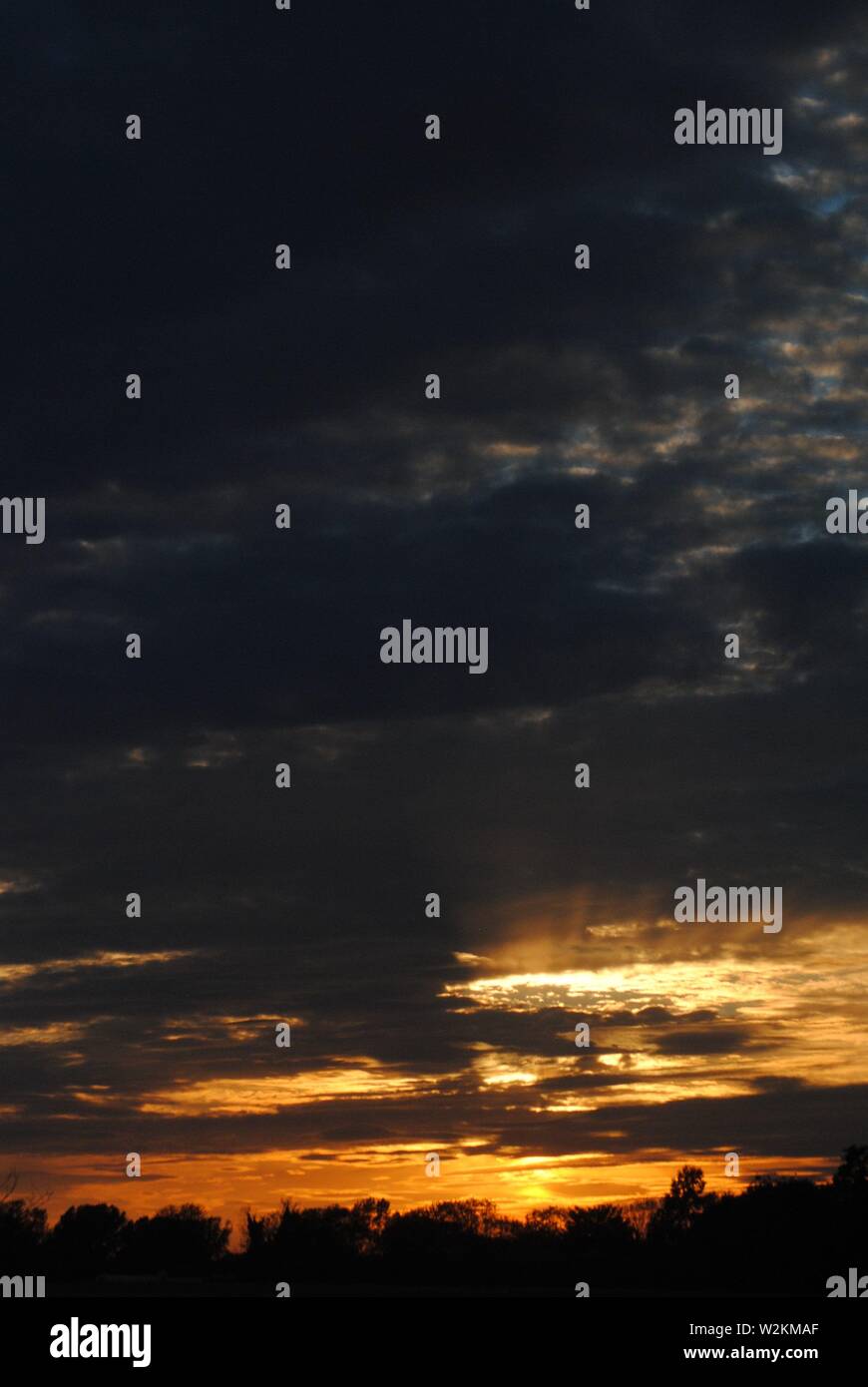 sunset over the fields of suffolk, summer orange yellow sun with dark ...