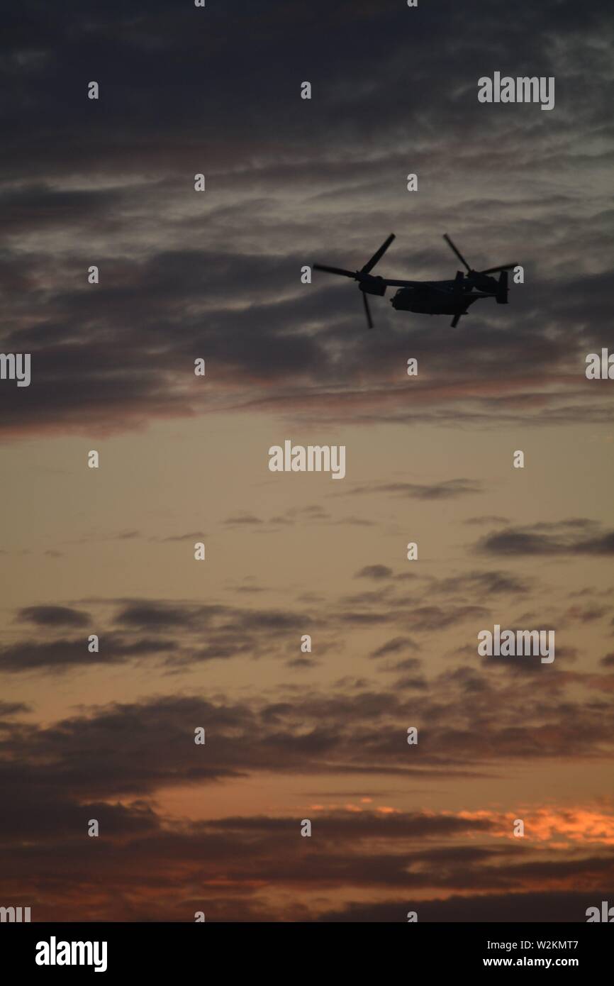 Osprey American air force plane silhouetted against evening clouds ...