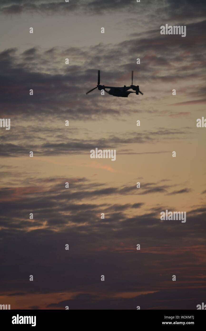 Osprey American air force plane silhouetted against evening clouds ...