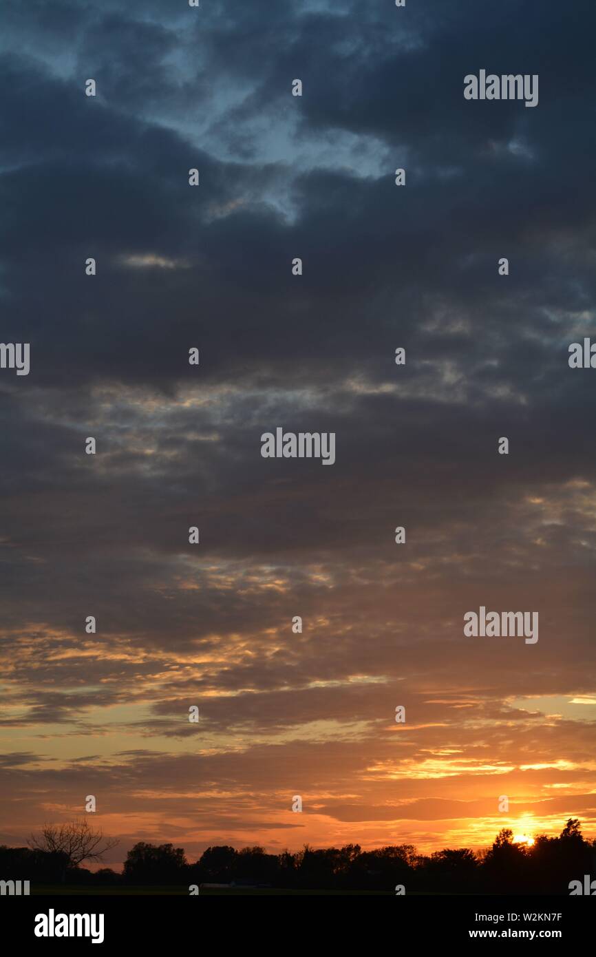 a collection of shots of the sun setting over the flat Suffolk fields ...