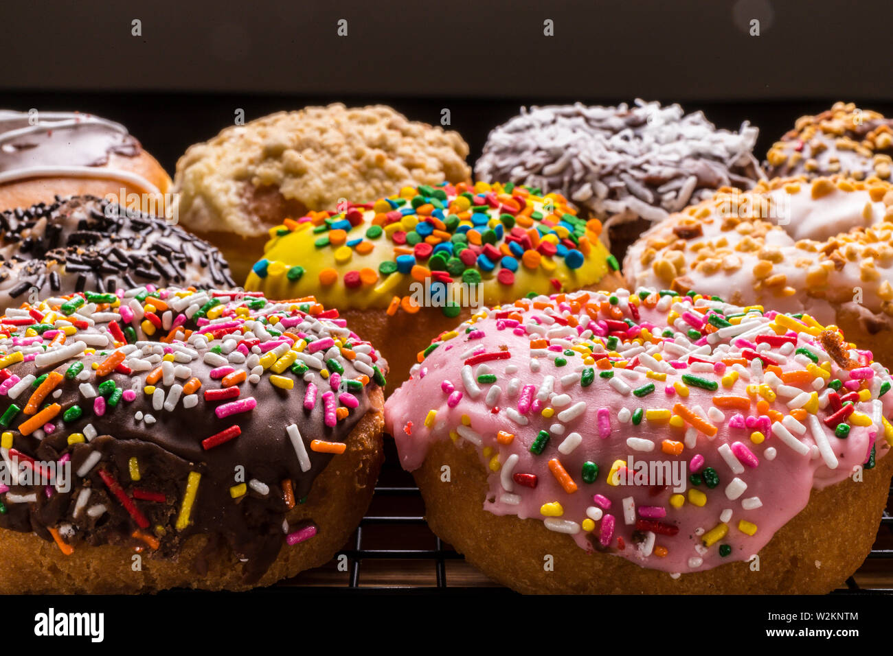 assorted donuts on wire rack on wooden cutting board Stock Photo - Alamy