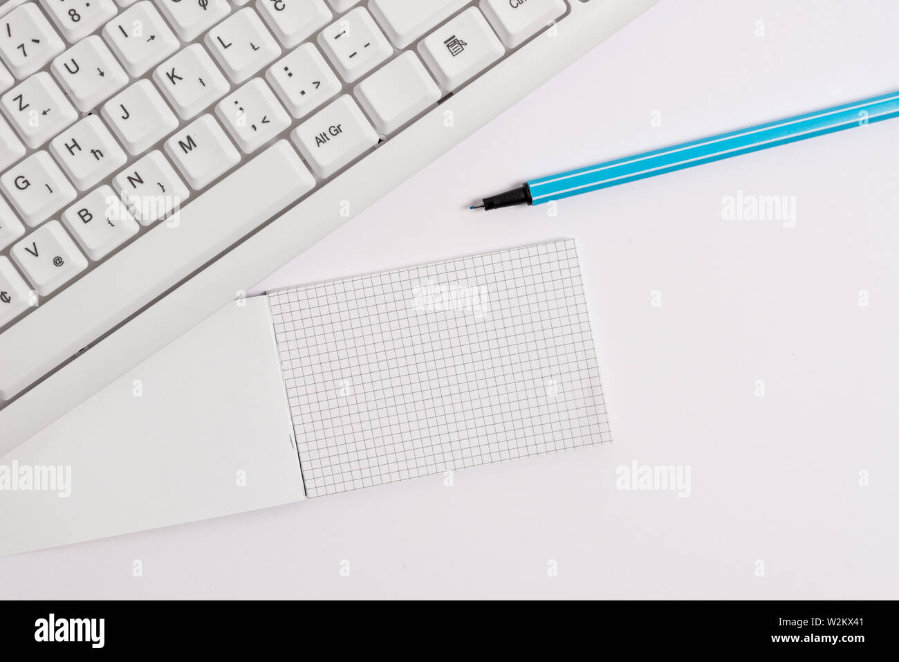 White pc keyboard with empty note paper above white background Stock ...