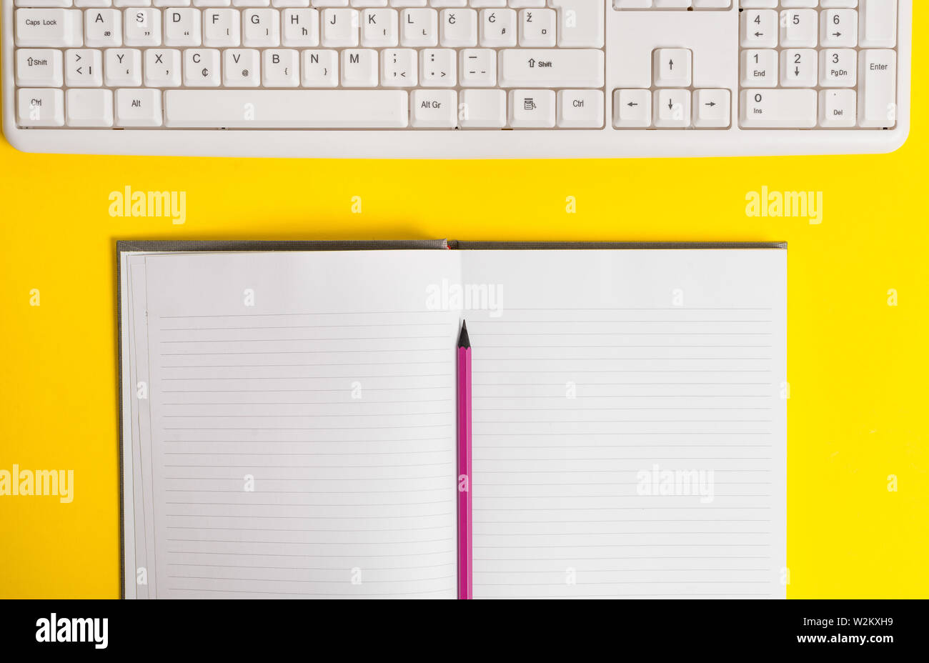 Copy space on notebook above yellow background with pc keyboard and ...