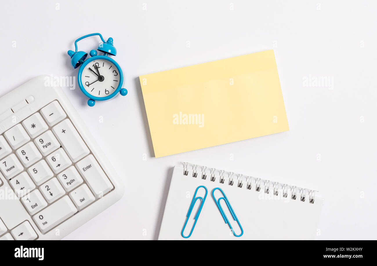 White pc keyboard with empty note paper and pencil above white ...