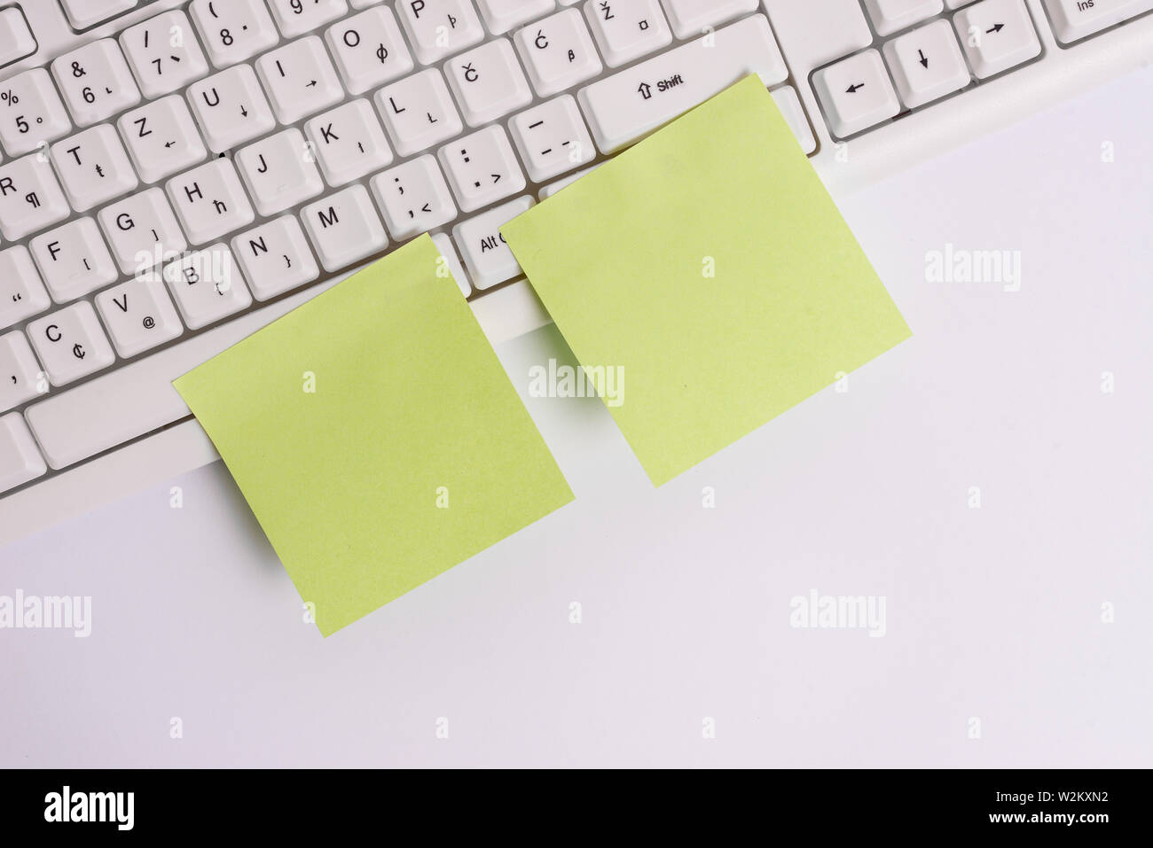 Square empty green note paper with pencil on the white background and ...