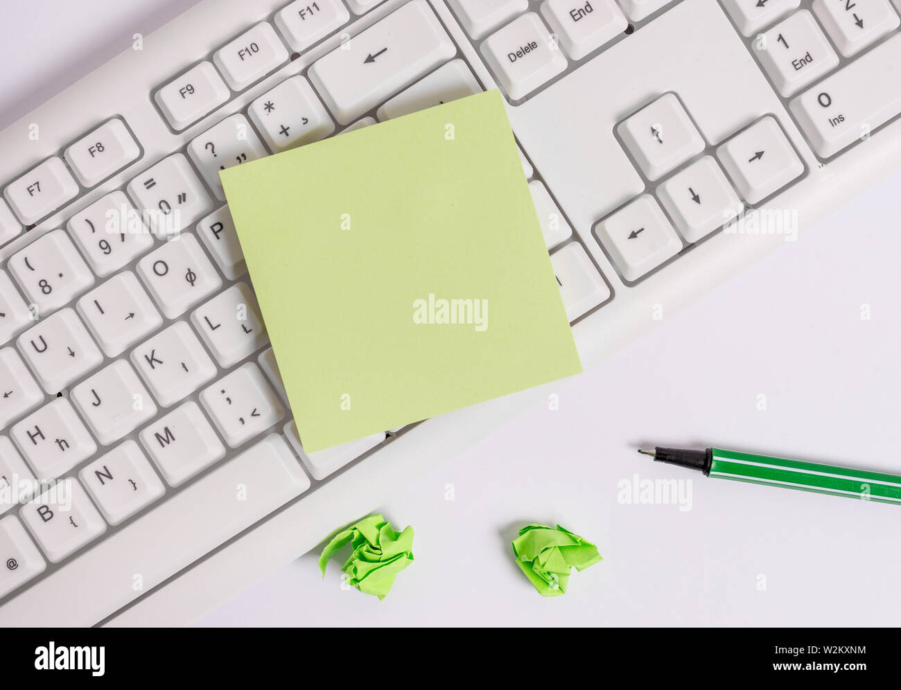 Square empty green note paper with pencil on the white background and ...