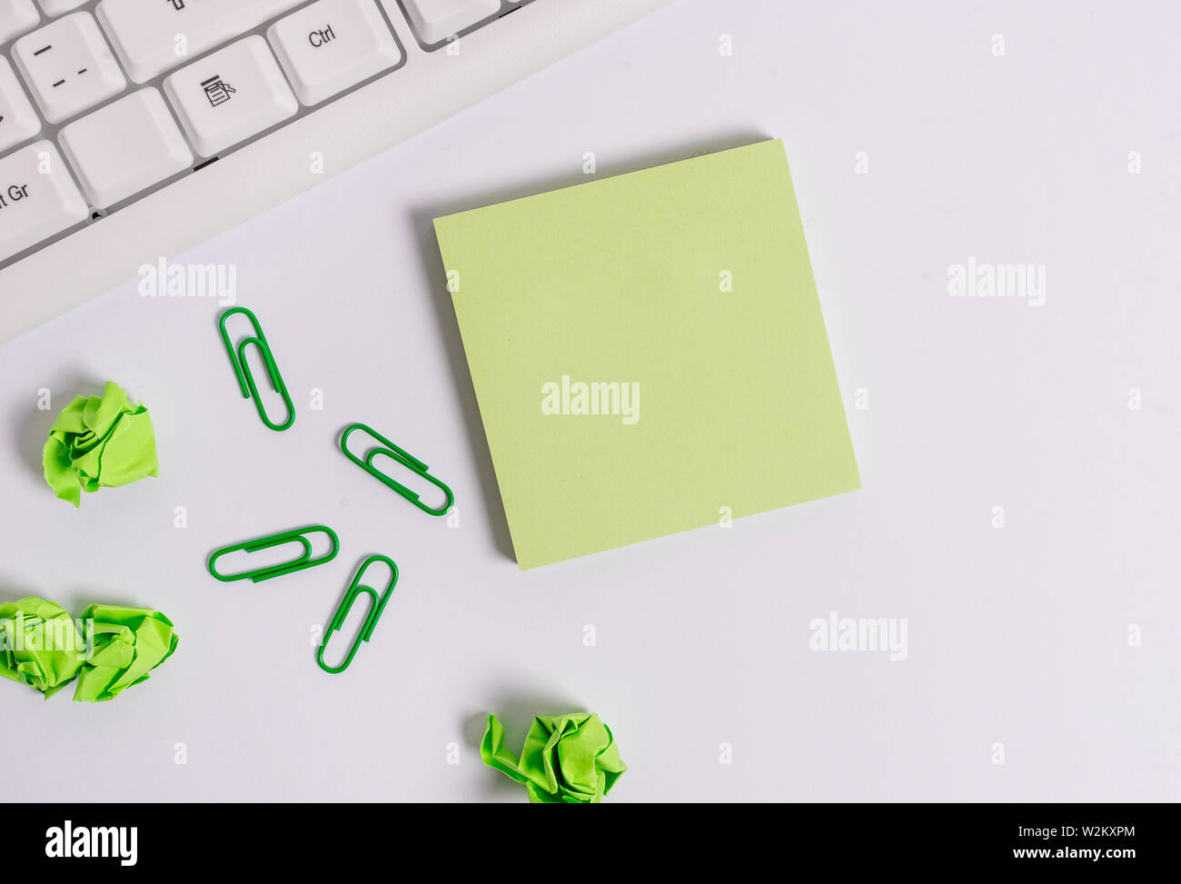 Square empty green note paper with pencil on the white background and ...