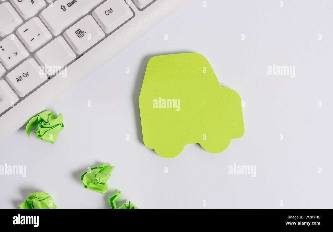 Green empty note paper in the shape of the car. Copy space on the green ...