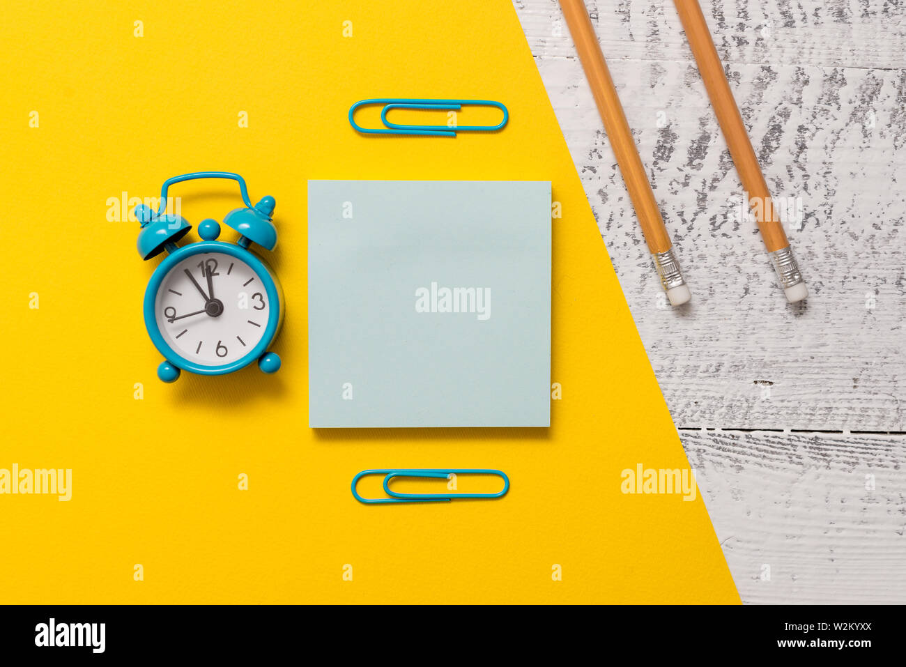 Notepad clips colored paper sheet markers alarm clock wooden background ...