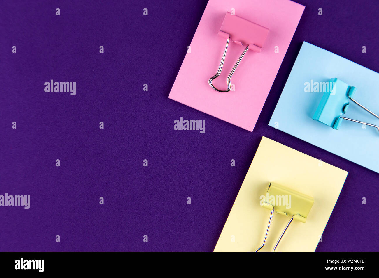 Notepad with set of colorful paper clips on purple background.business ...