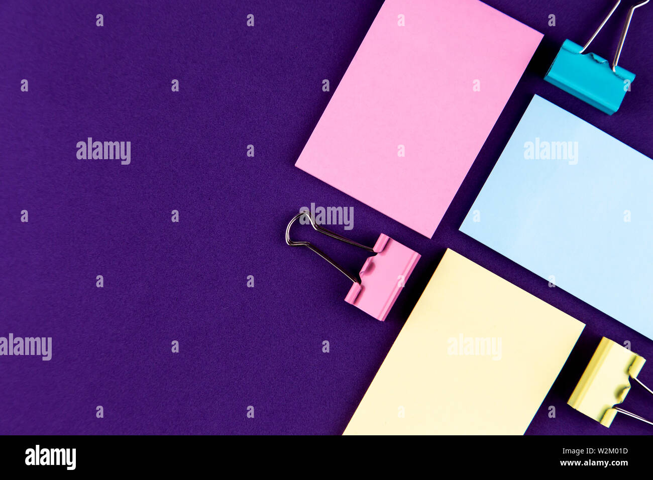 Notepad with set of colorful paper clips on purple background.business ...