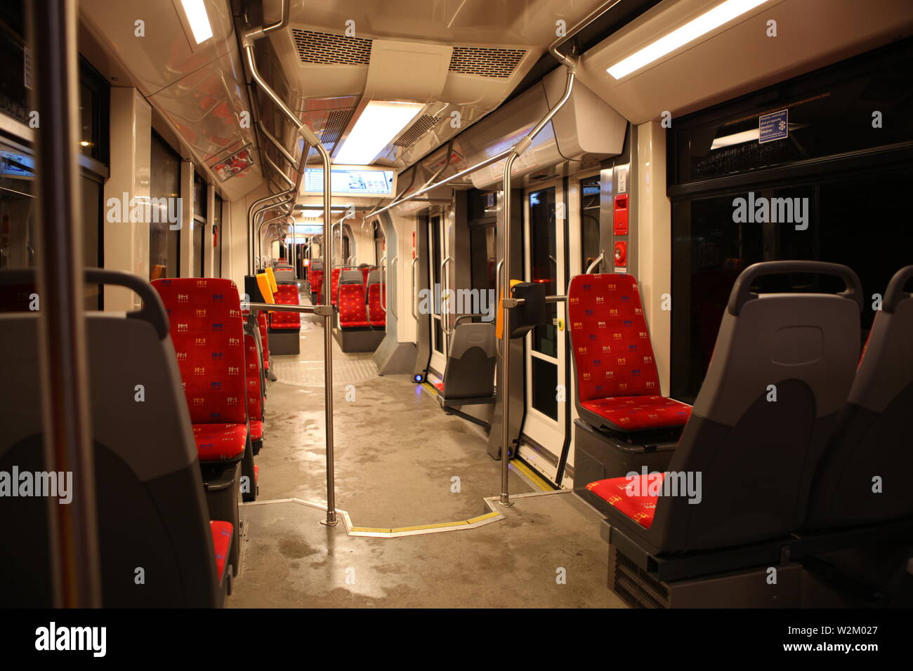 Interior of empty modern tram with red seats. Night Stock Photo - Alamy