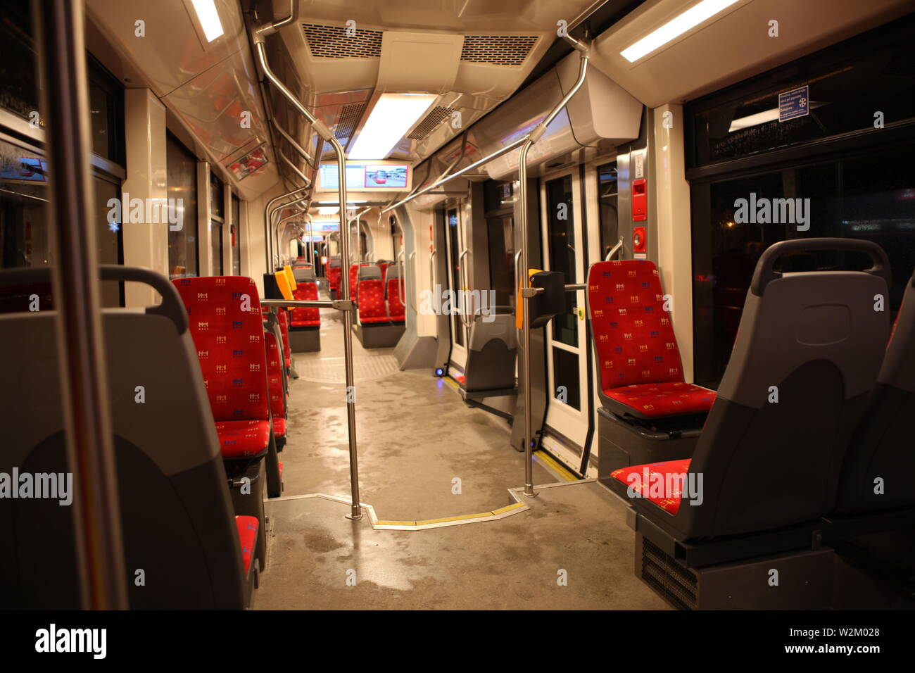 Interior of empty modern tram with red seats. Night Stock Photo - Alamy