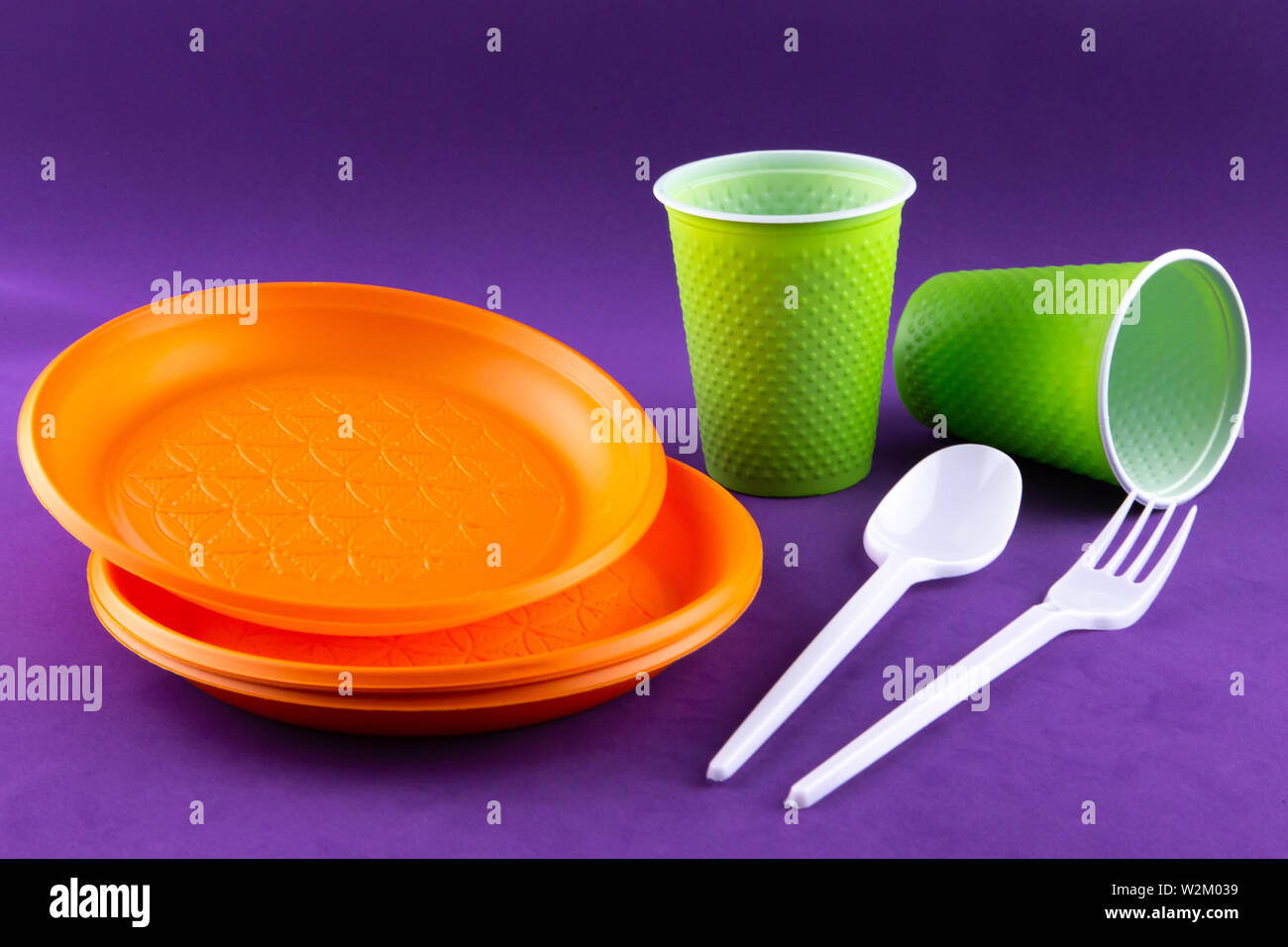 Plastic orange green waste collection on purple background. Concept of ...