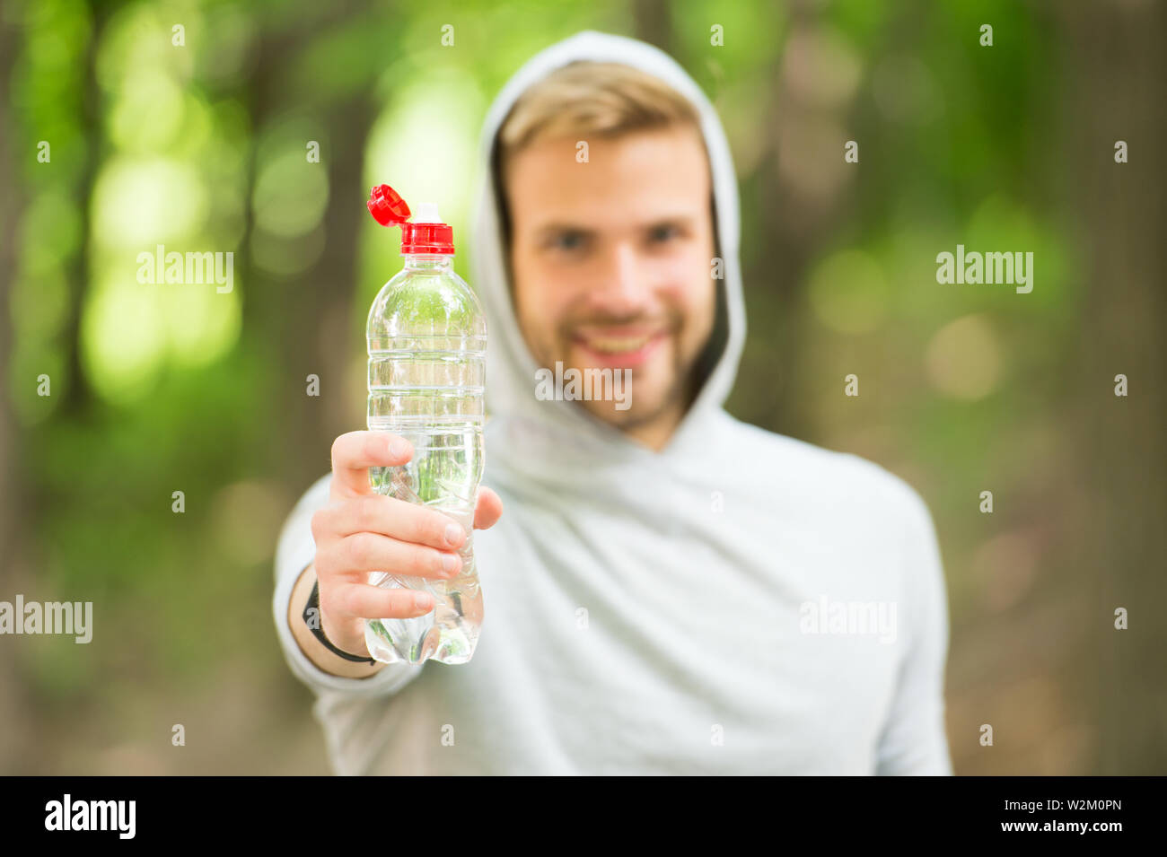 Stay hydrated. Man athletic sportsman hold bottle water. Man athlete ...