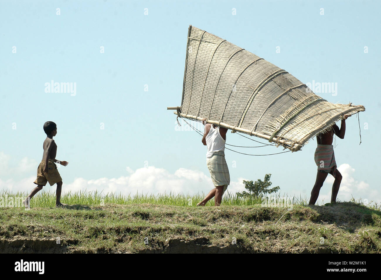 Fisher men carrying fishing tool called 'ucha' through the river side ...