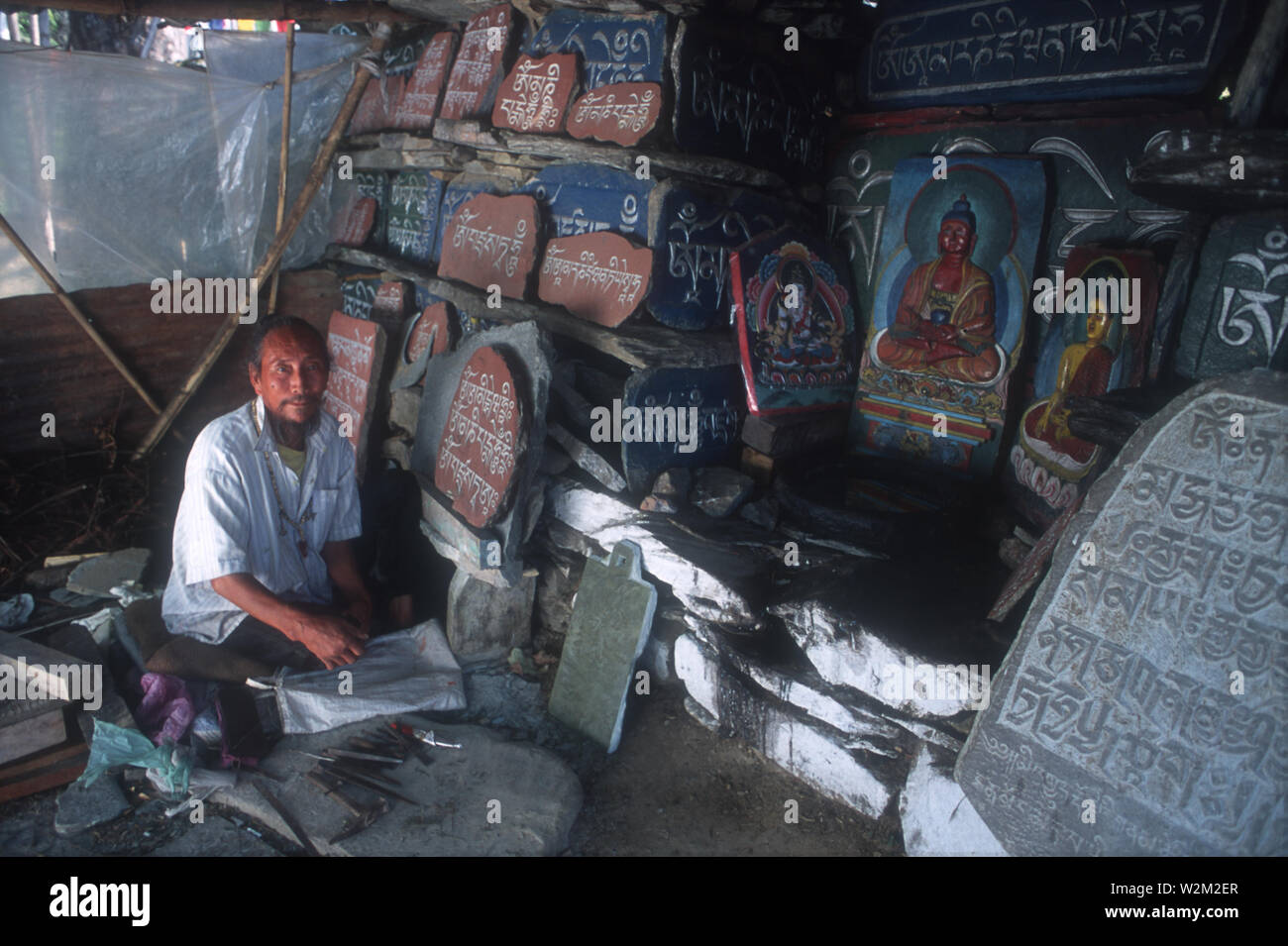 A stone carver, in a monastery, in Sikkim. He carves prayers and hand ...