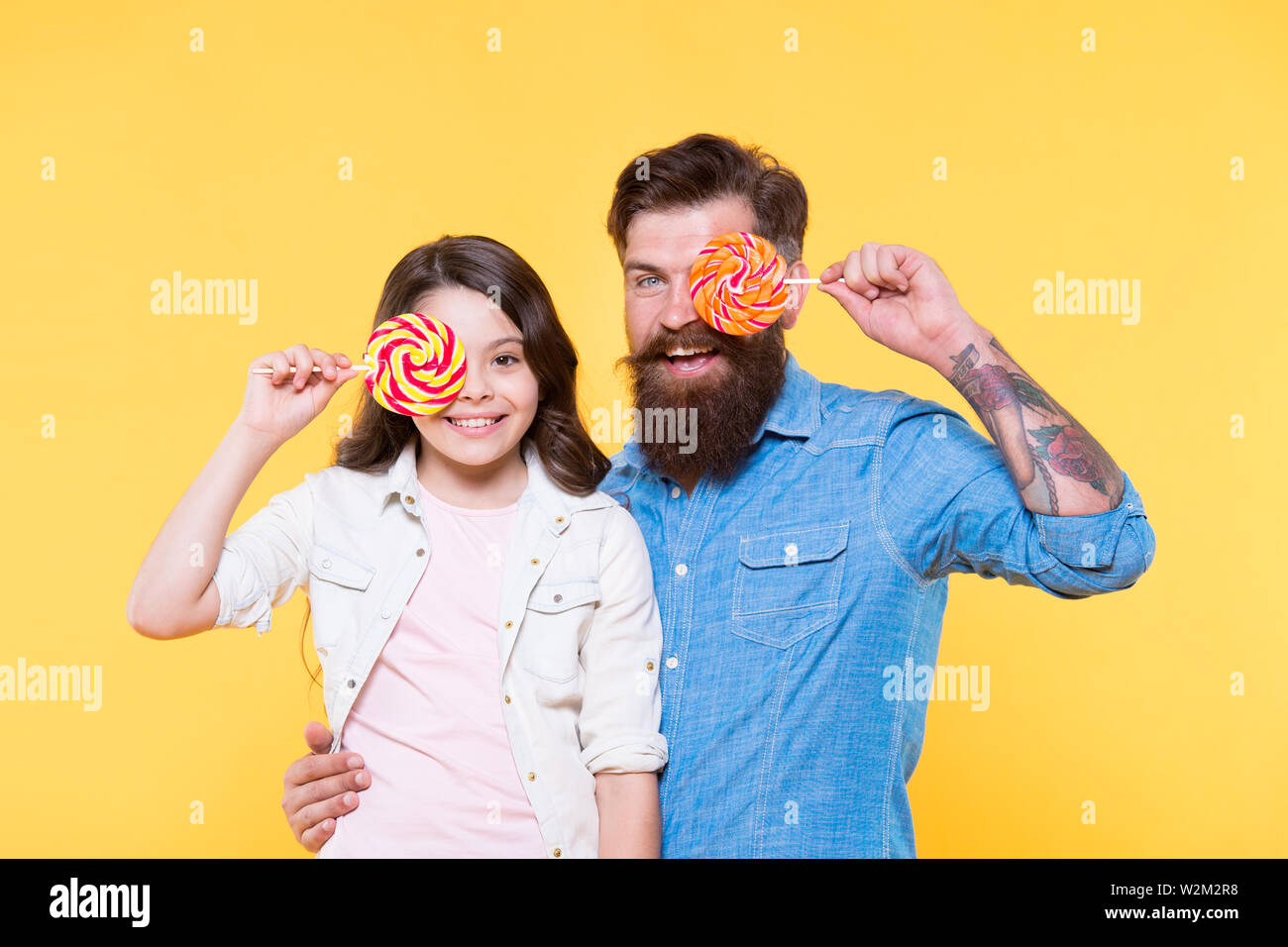 Sweet childhood. Girl child and dad hold colorful lollipops. Sweet ...
