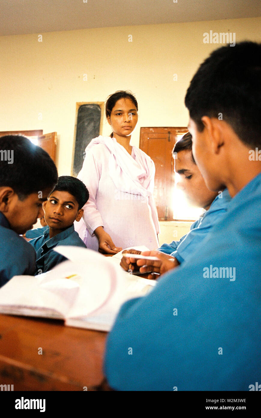 A teacher checks the classwork of boys at the Edhi Child Home ...
