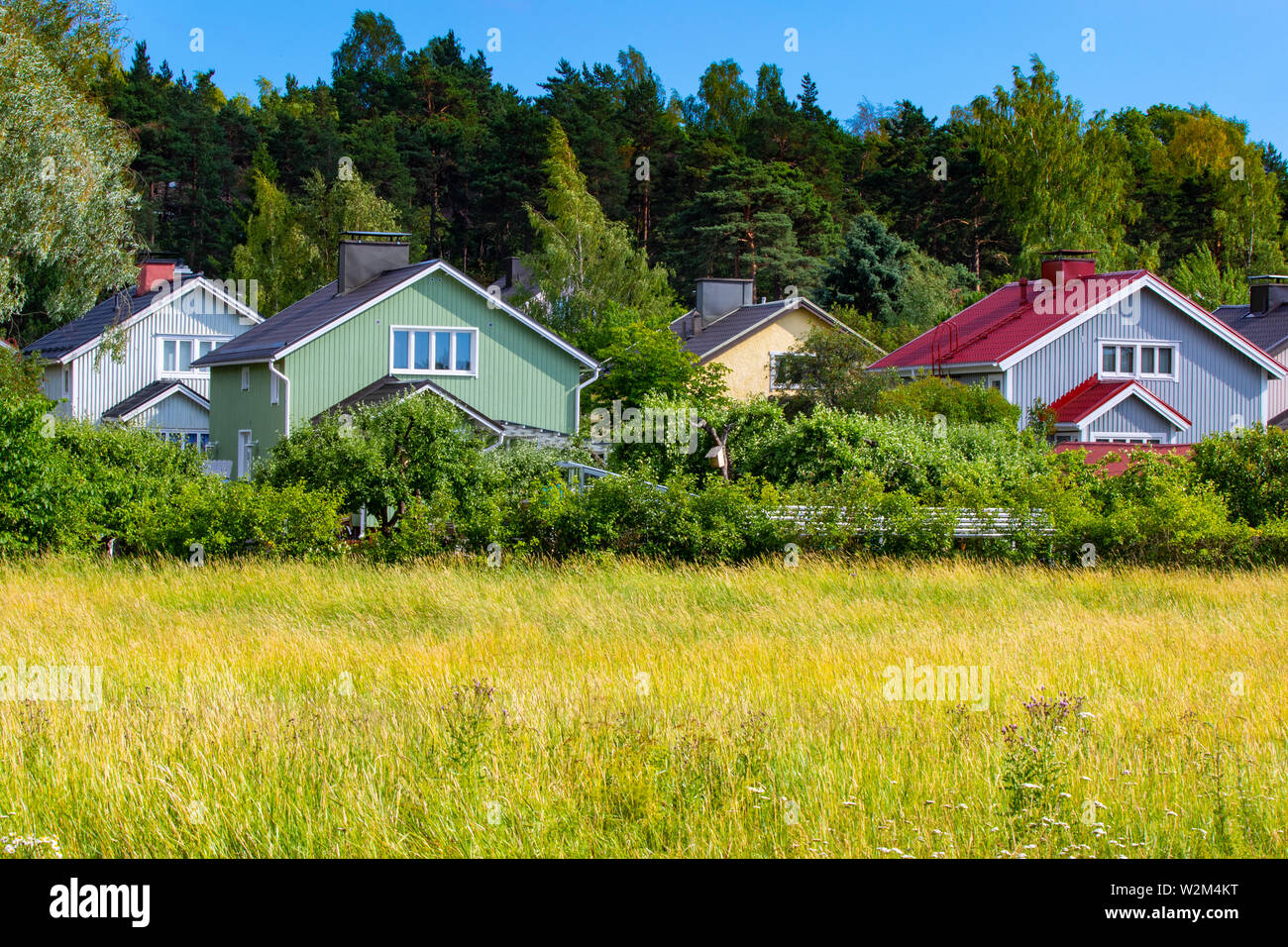 Colorful wooden homes nestled among lots of greenery in a suburb of ...
