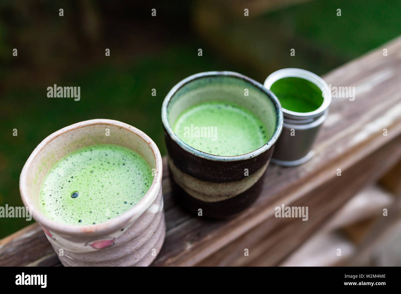 Wooden backyard deck garden railing and two cups with Japanese green ...
