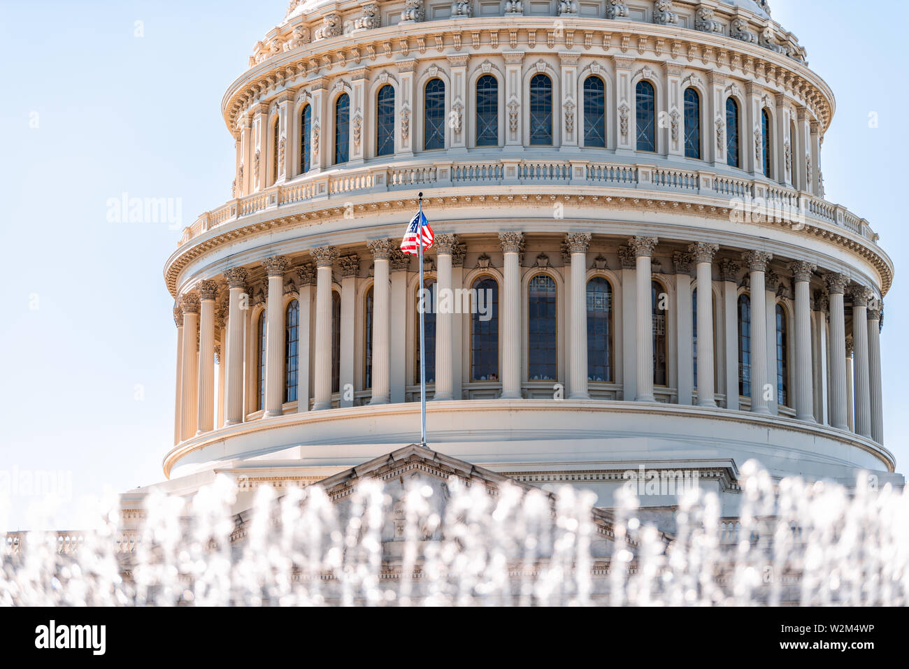 US Congress dome with background of water fountain American flag waving ...