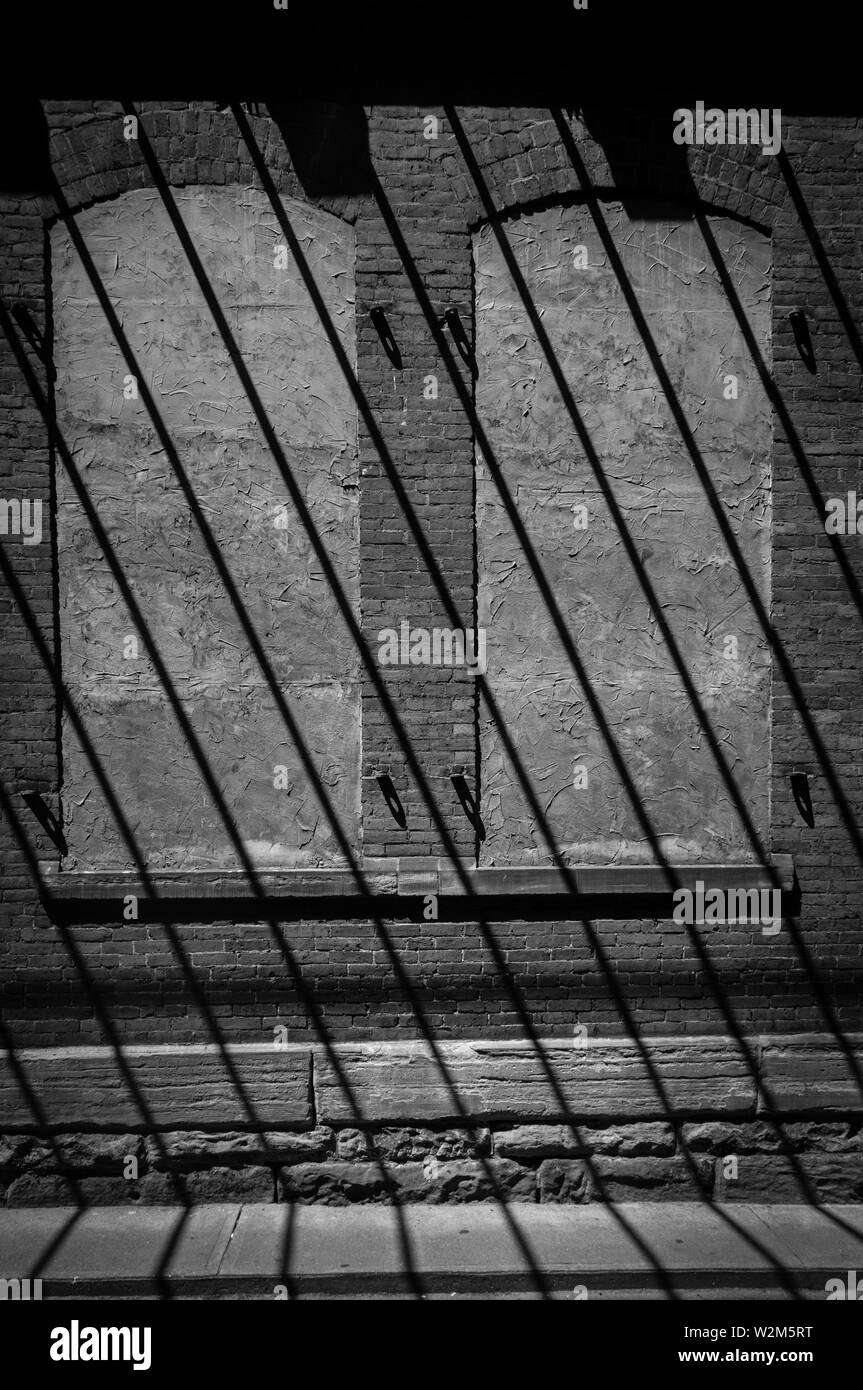 Diagonal shadows make an interesting pattern over two boarded up ...