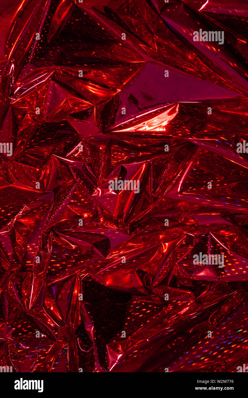 The background of crumpled holographic packaging film with an abstract ...