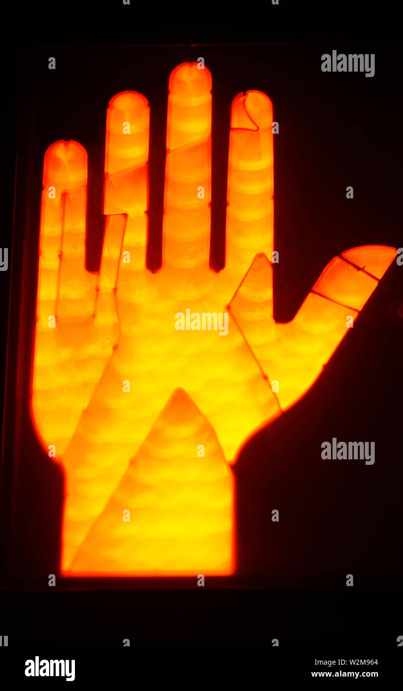 Illuminated orange / red stop walking sign taken at night in ...