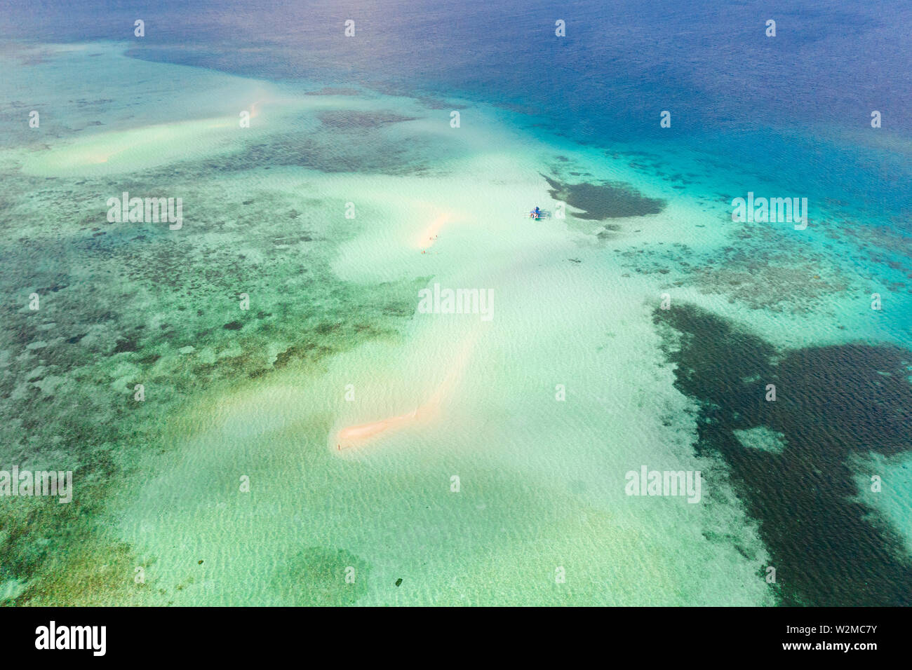 Coral reef with turquoise water and sandy shoals. Large atoll with ...