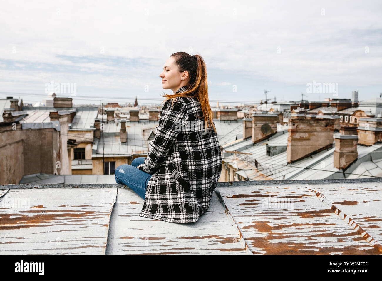 Girl sitting on roof house hi-res stock photography and images - Alamy