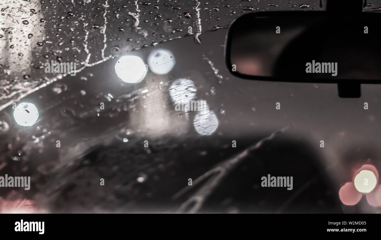 Interior of car when rains. Defocused blur of light on the road in a ...