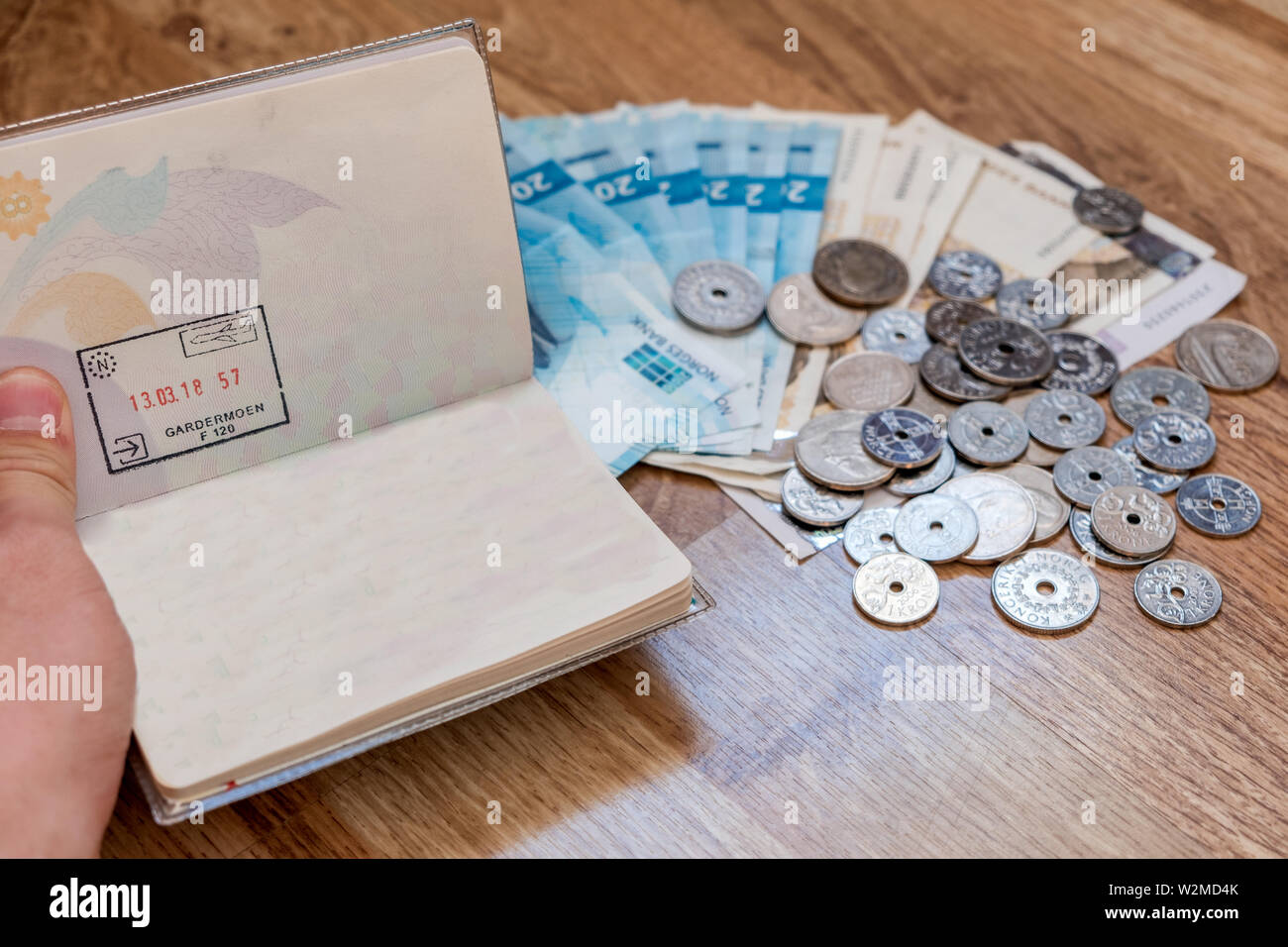 Hand checking Passport with currency coins with cash of nok in norway ...