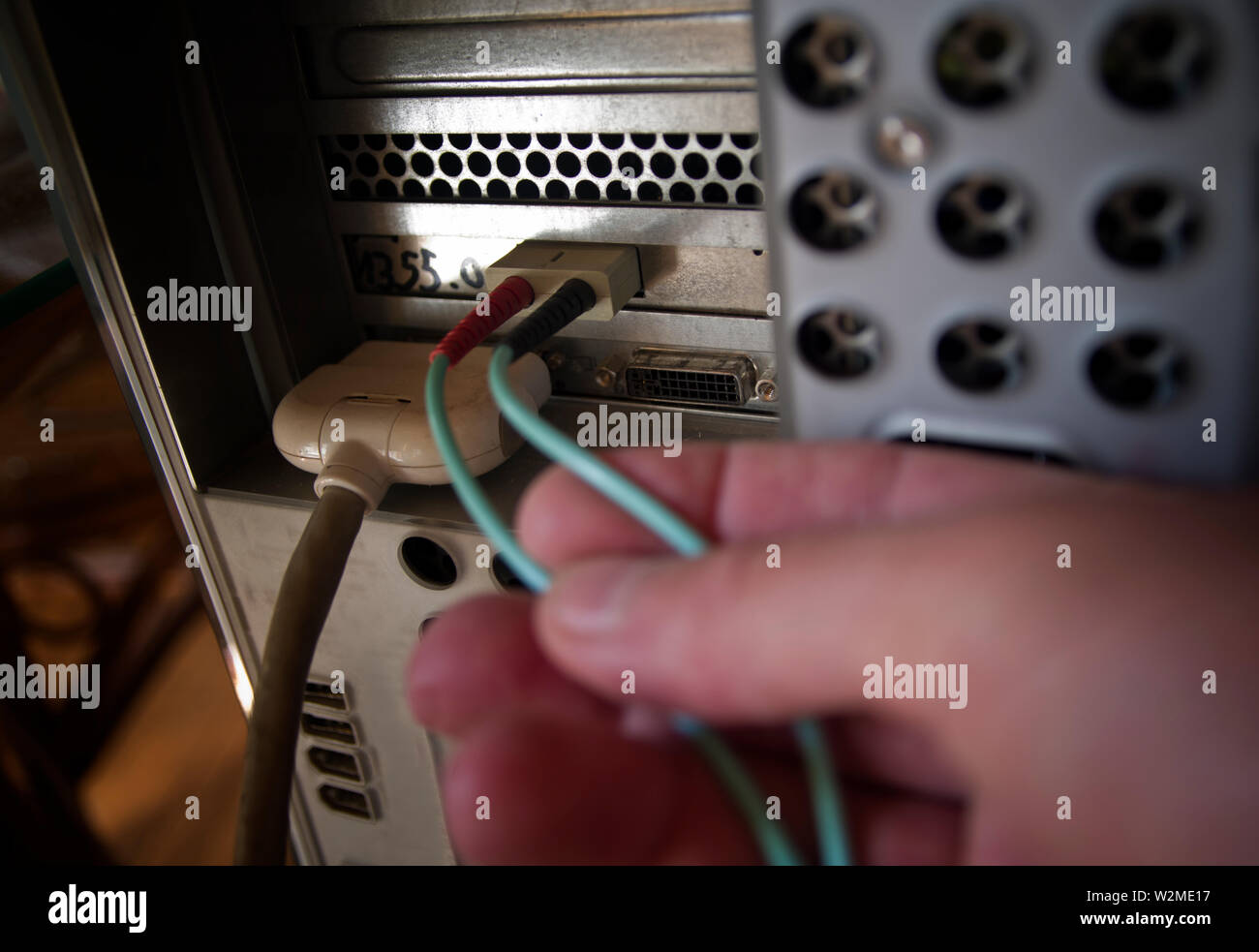 Hand arranging a cable inserted on a rear of computer to set good ...